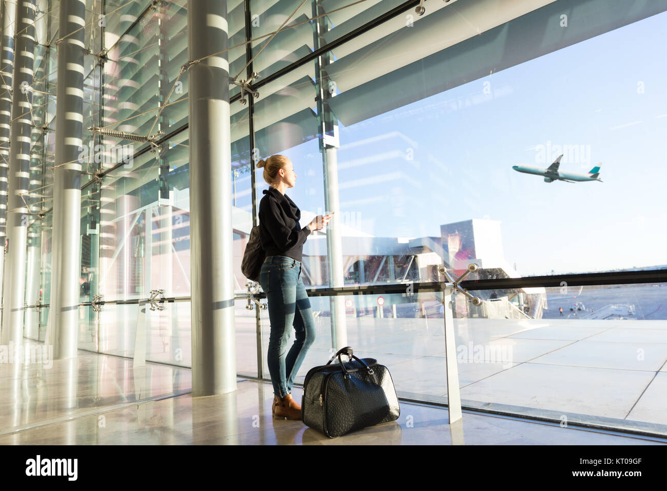 Young woman waiting at airport, looking through the gate window Stock ...