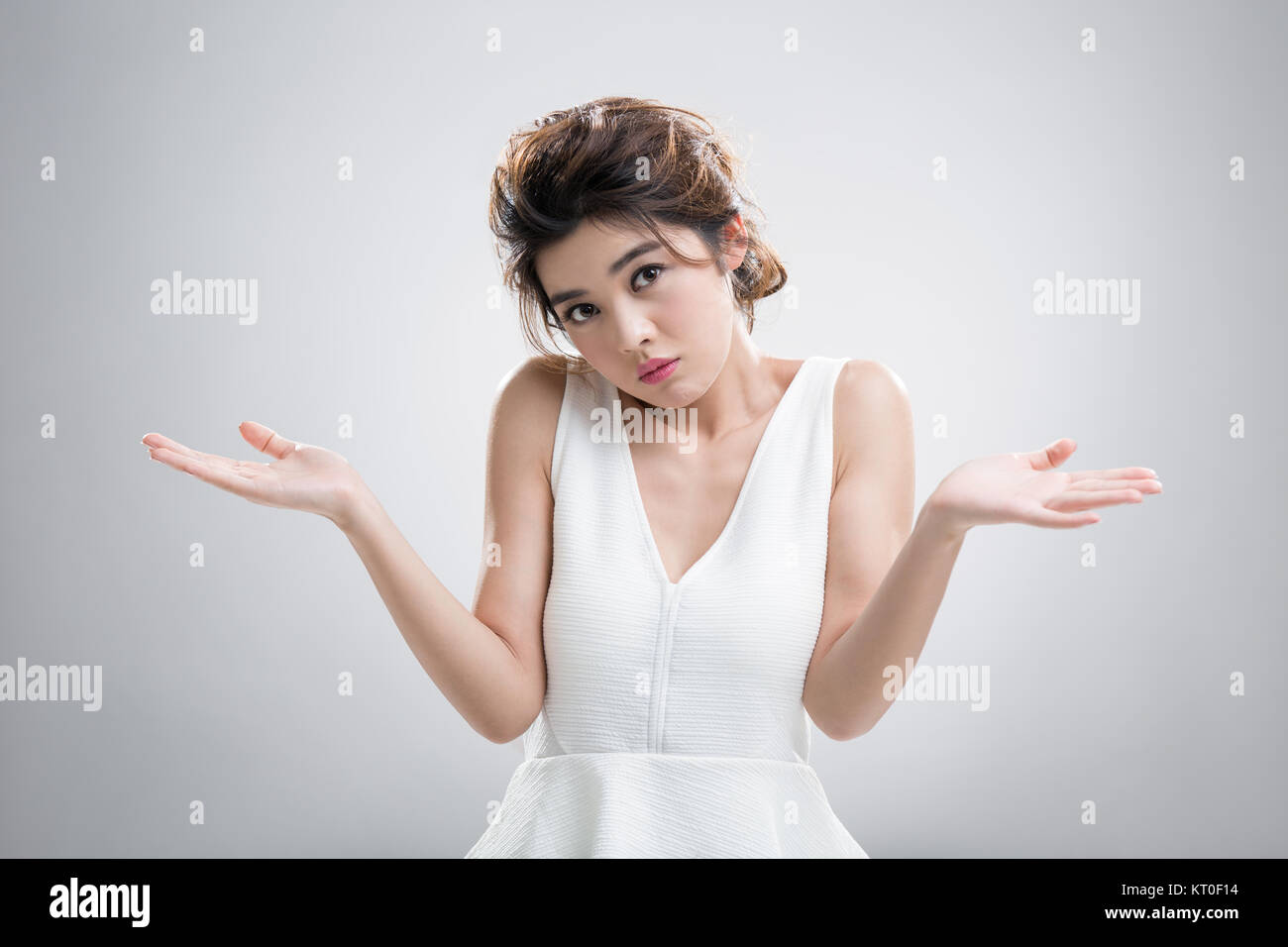 Young woman shrugging her shoulders Stock Photo - Alamy