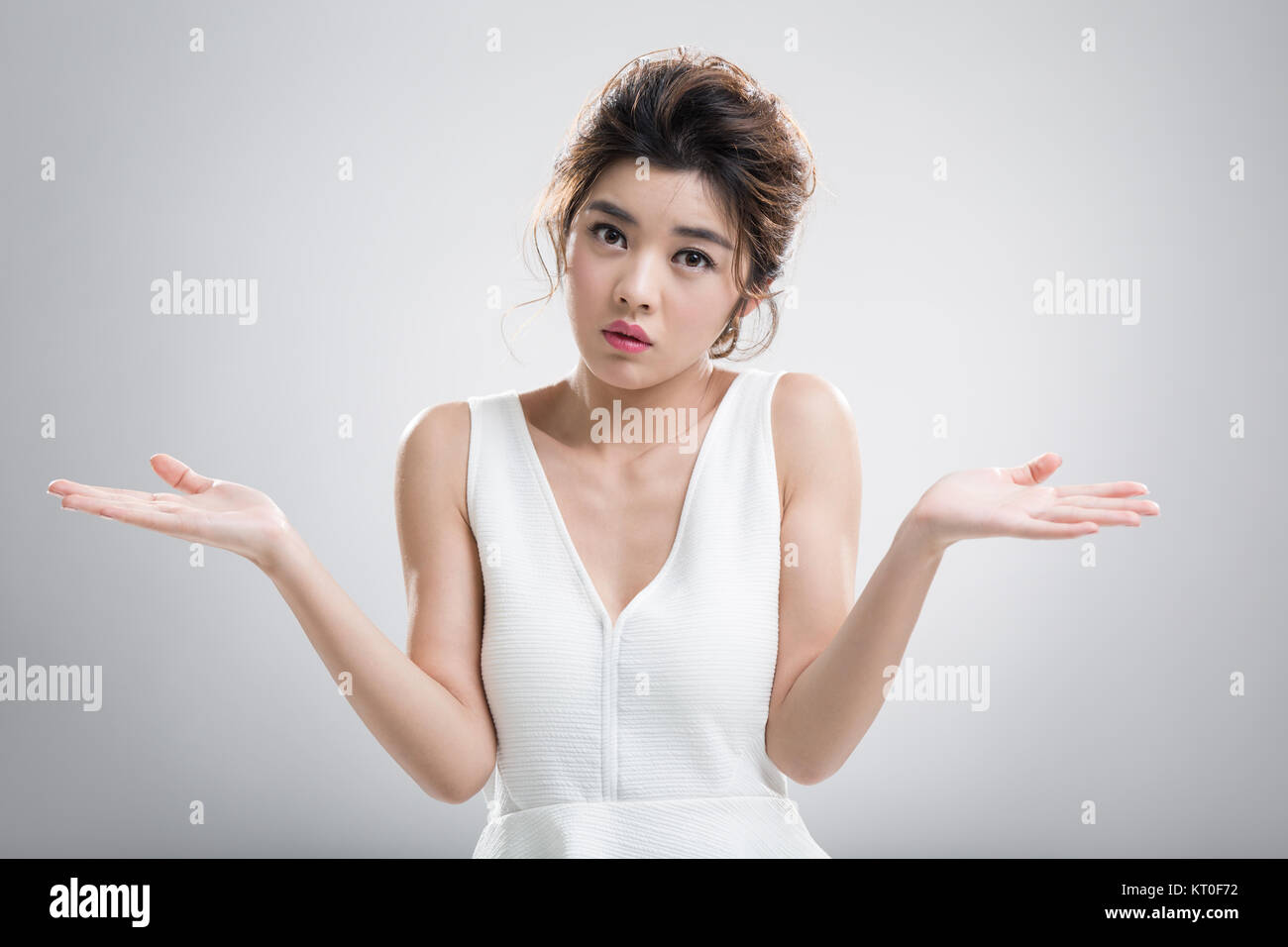 Young woman shrugging her shoulders Stock Photo - Alamy