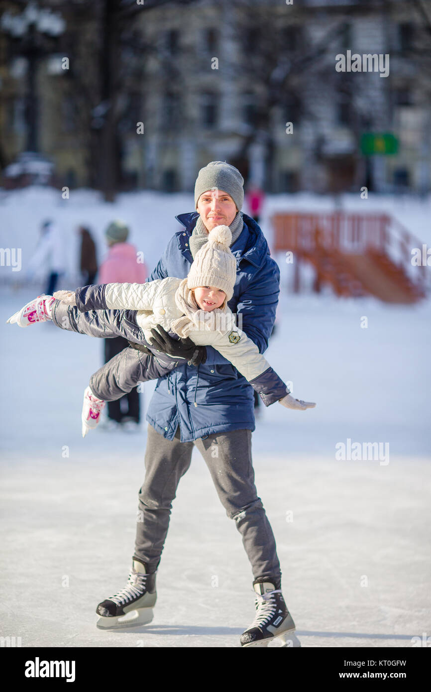 Family of father and kid having fun on skating rink outdoors Stock ...