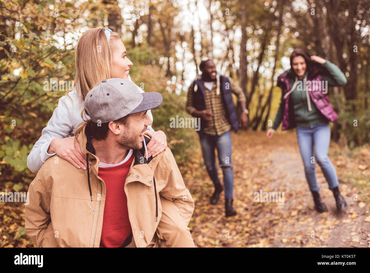Happy friends having fun in forest Stock Photo - Alamy