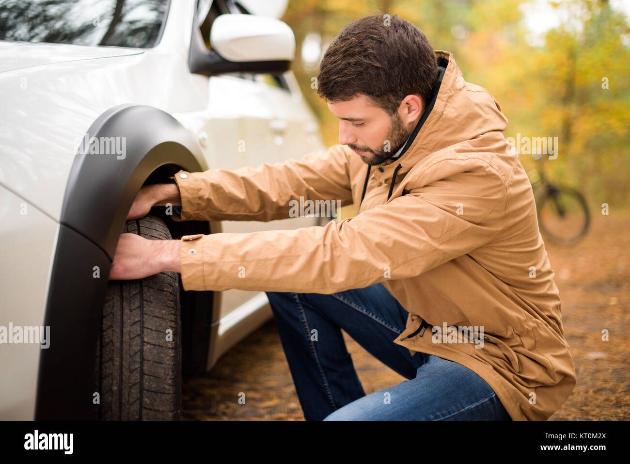 Man checking car tyre Stock Photo - Alamy