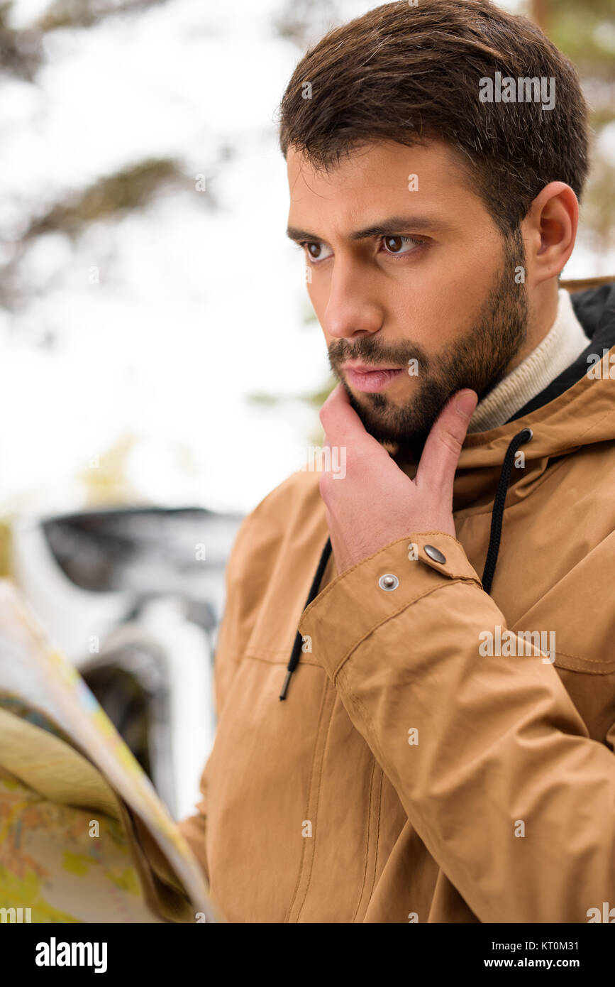 Bearded man holding map in forest Stock Photo - Alamy