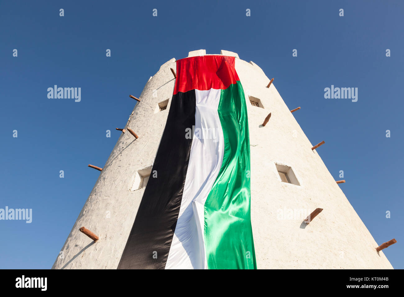 Old tower in Abu Dhabi decorated with huge UAE flag for the celebration ...