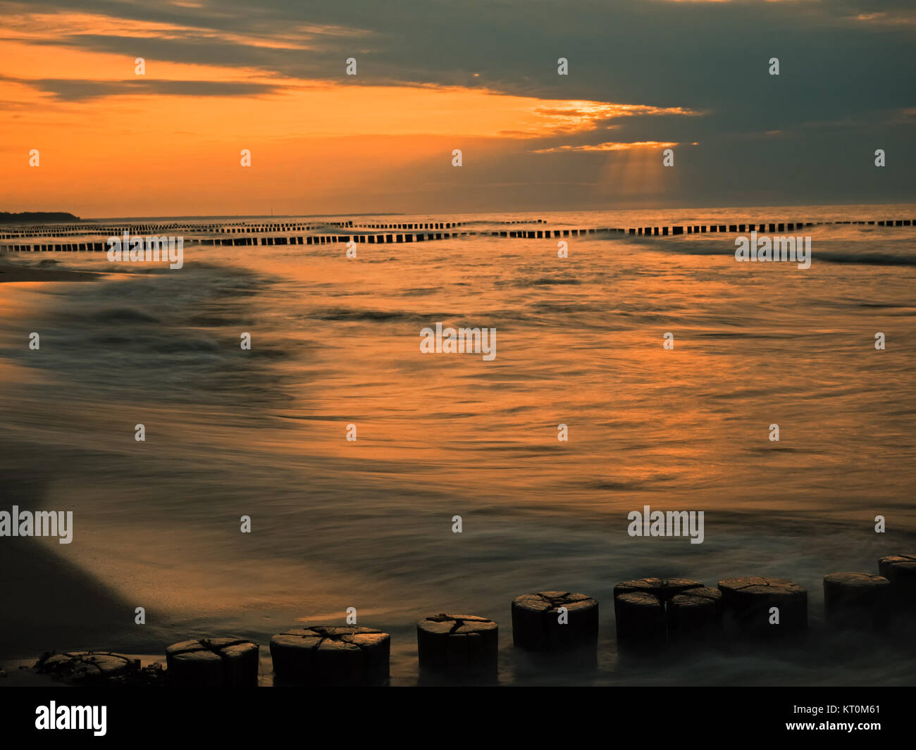 Baltic Sea with breakwaters at sunset Stock Photo - Alamy