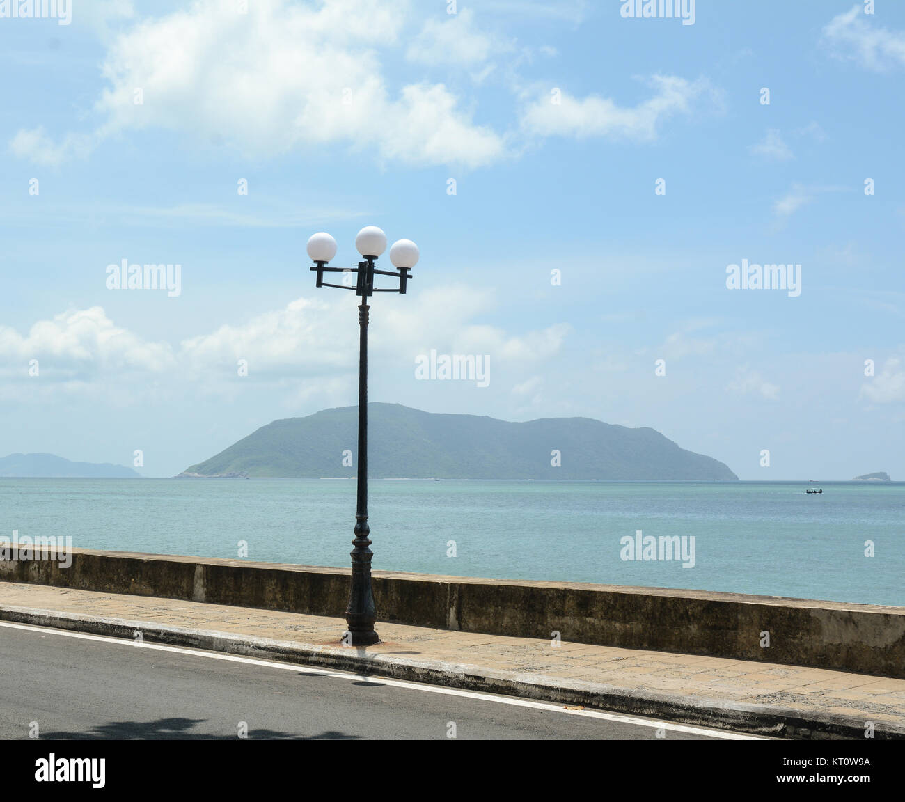 Lamp post on rural road with seascape background Stock Photo - Alamy