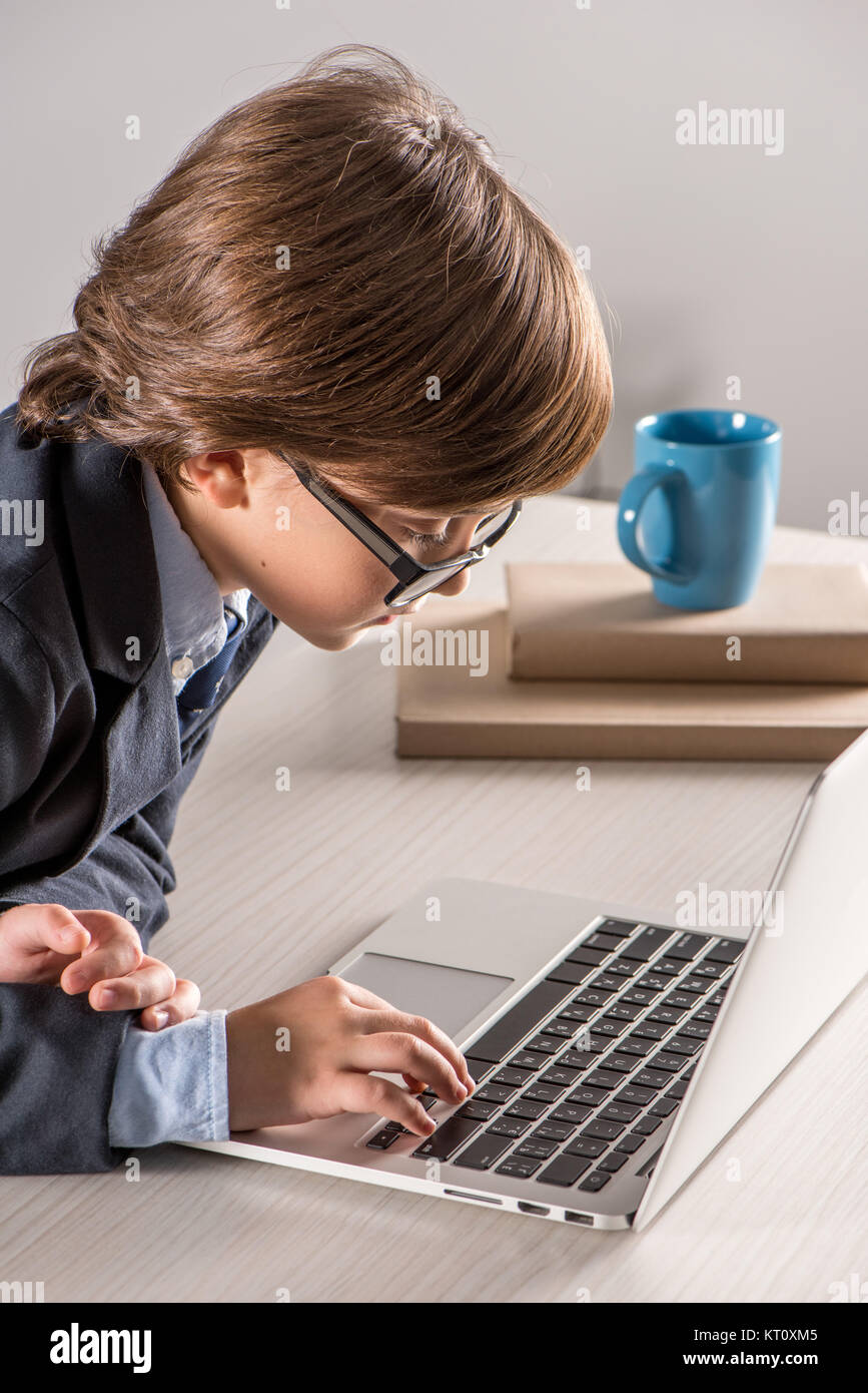 Schoolchild in business suit using laptop computer Stock Photo - Alamy