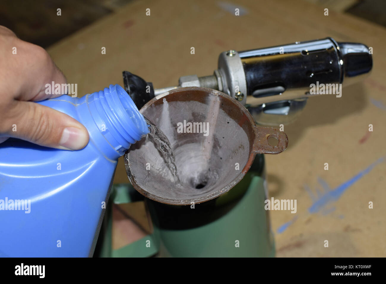 Pouring gasoline blowtorch through the funnel Stock Photo - Alamy