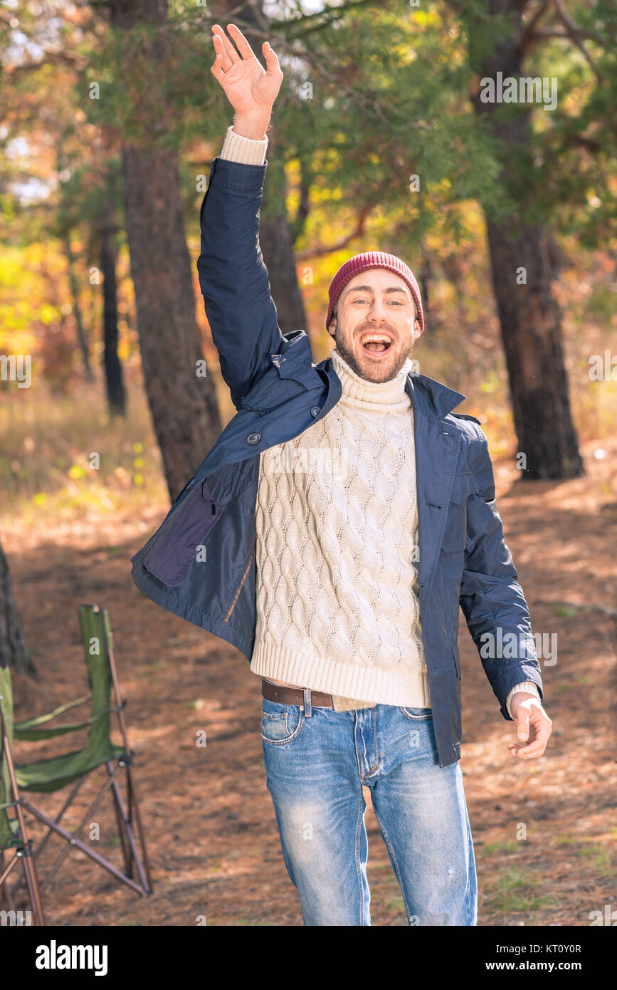 Smiling man waving hand Stock Photo - Alamy