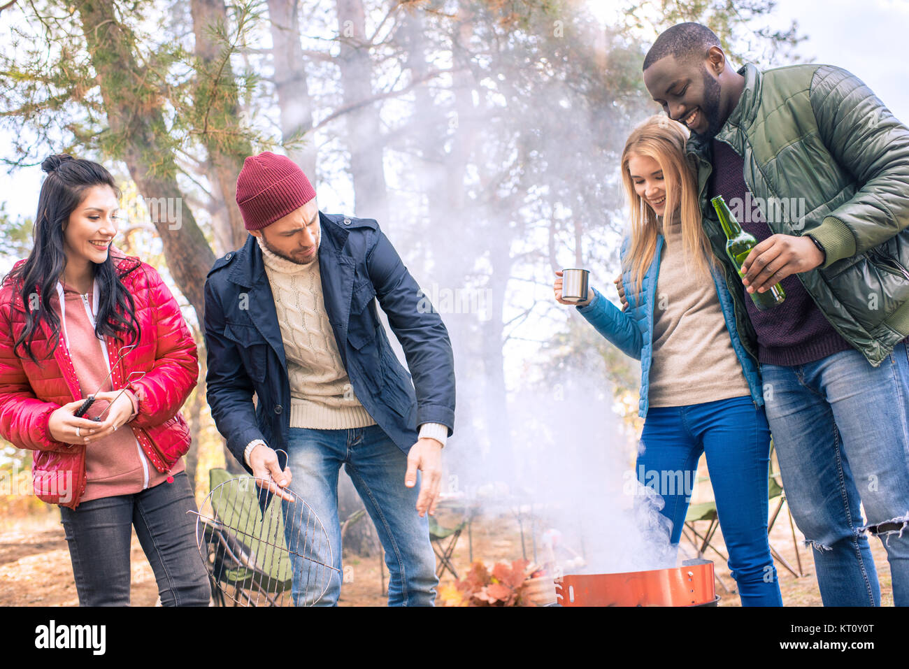 Smiling friends having fun in campsite Stock Photo - Alamy