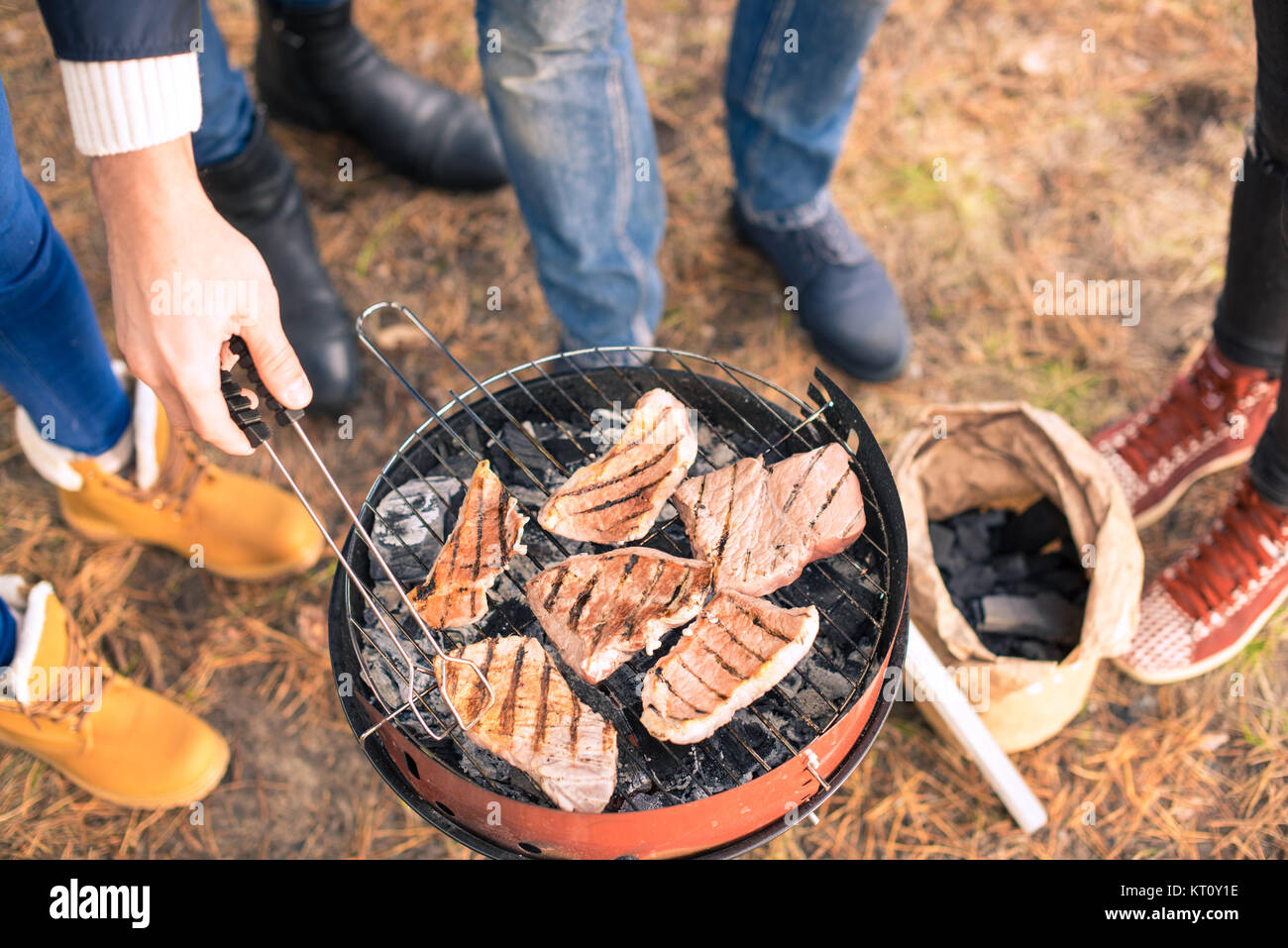 People cooking meat on charcoal grill Stock Photo - Alamy