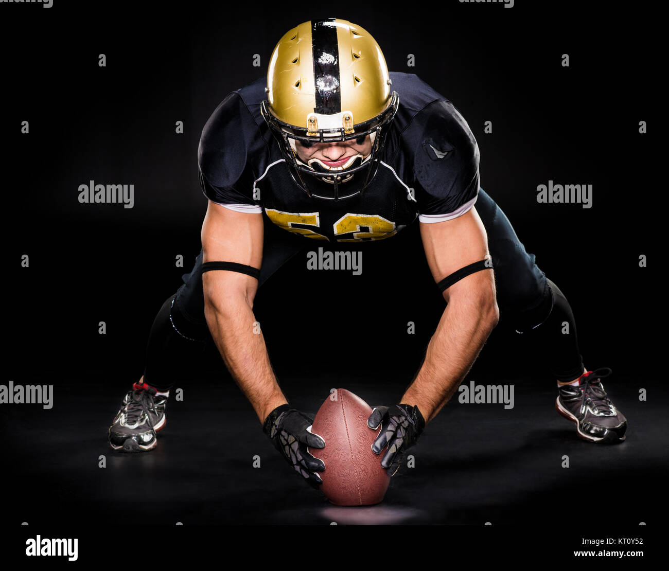 American football player holding ball Stock Photo - Alamy