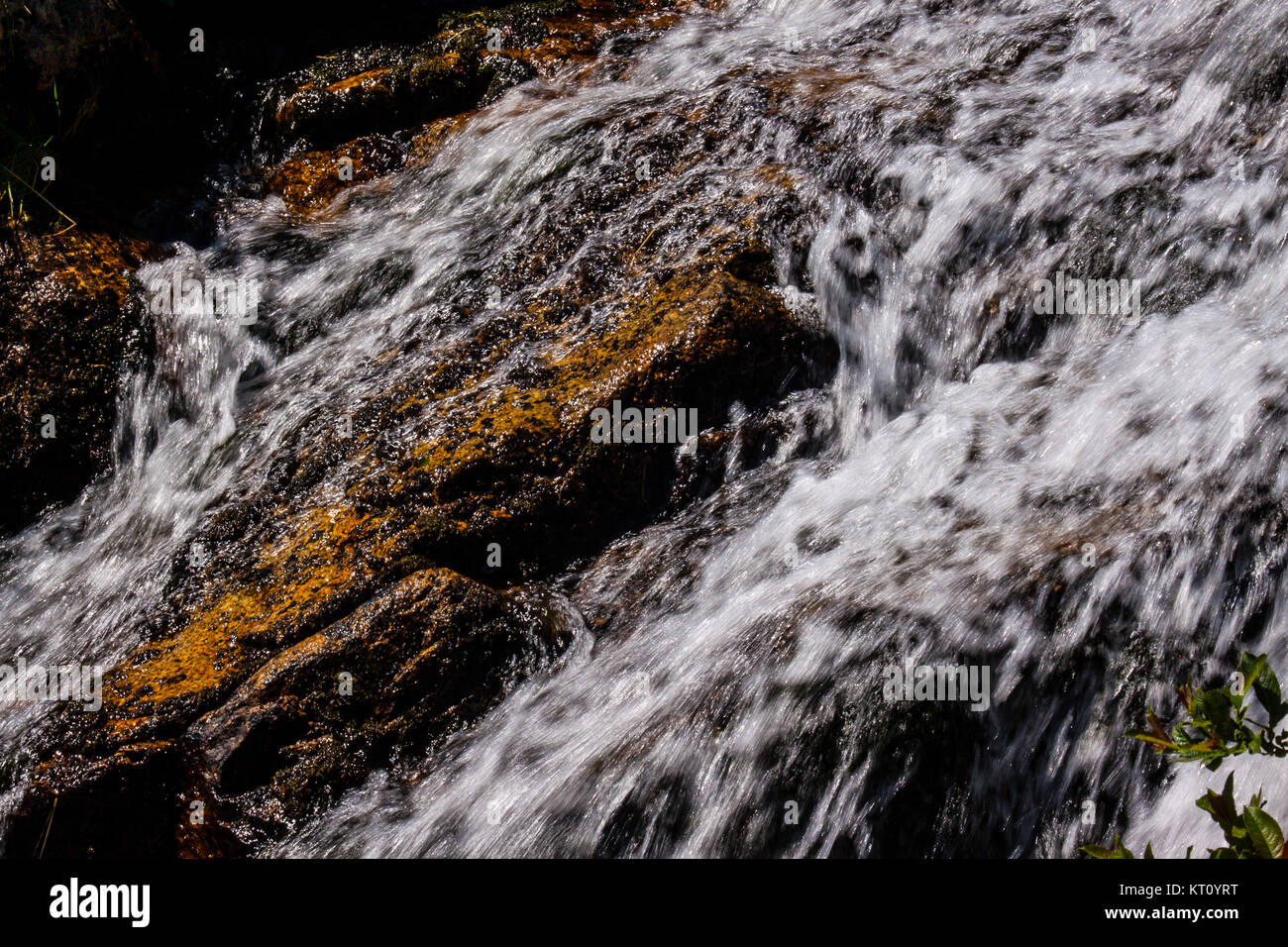 fast flowing water across the rocks in the mountains Stock Photo - Alamy