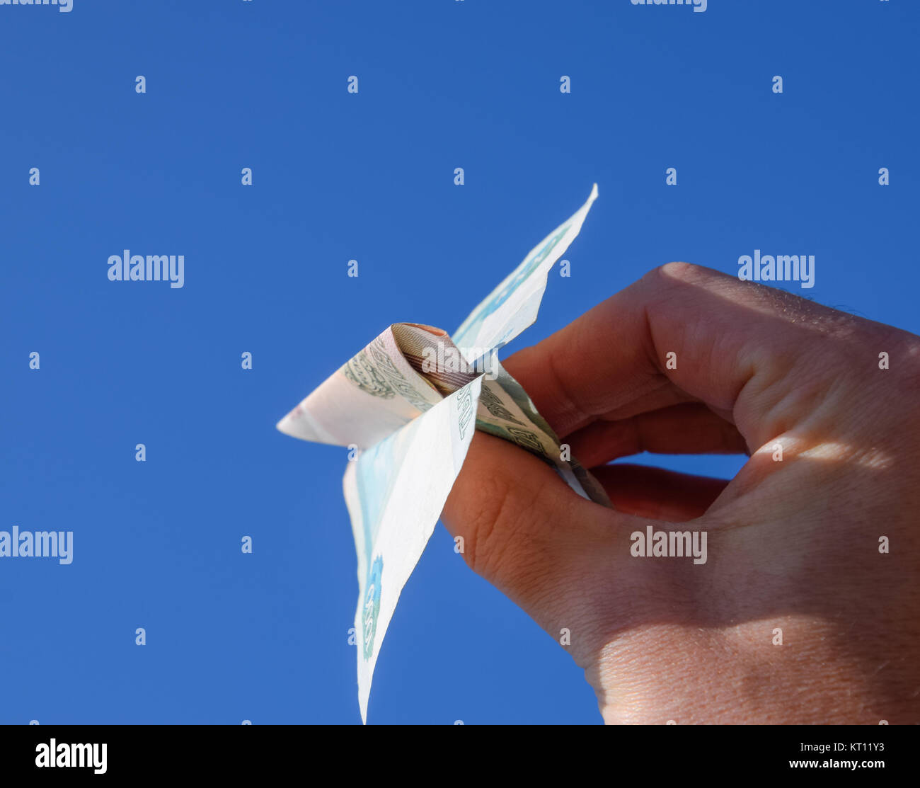 Denominations of Russian money, folded in the airplane against the blue ...