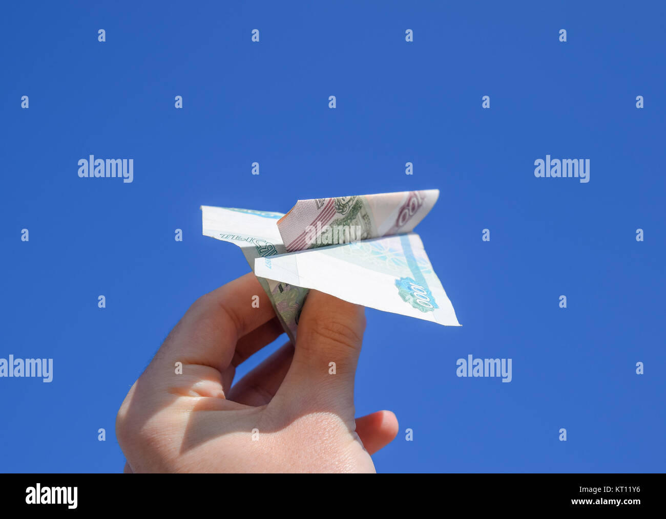 Denominations of Russian money, folded in the airplane against the blue ...