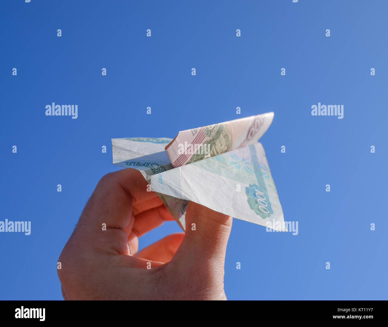 Denominations of Russian money, folded in the airplane against the blue ...