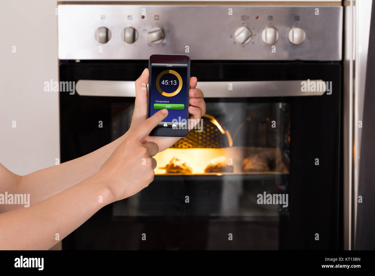 Person Operating Oven Appliance With Mobile Phone Stock Photo - Alamy