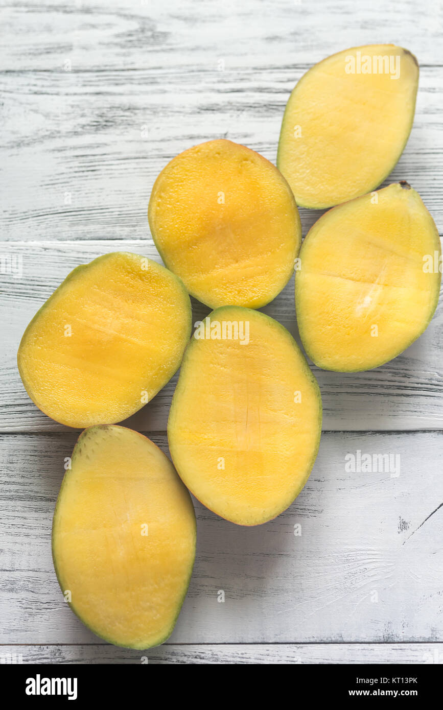 Halves of mango on the wooden background Stock Photo - Alamy