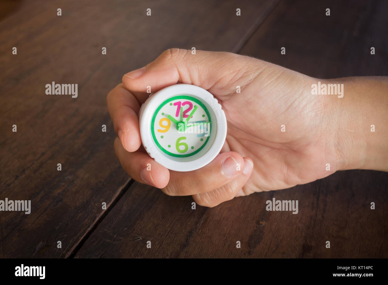 Mini white clock in hand Stock Photo - Alamy