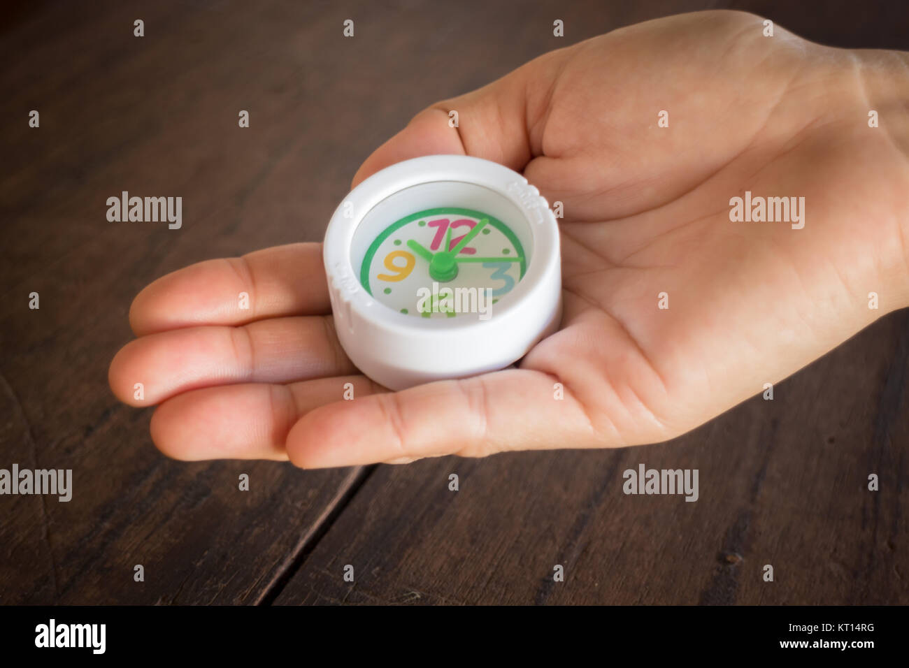 Mini white clock in hand Stock Photo - Alamy