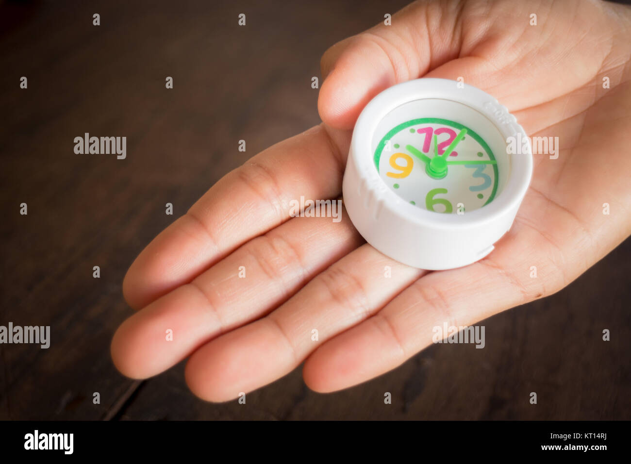 Mini white clock in hand Stock Photo - Alamy