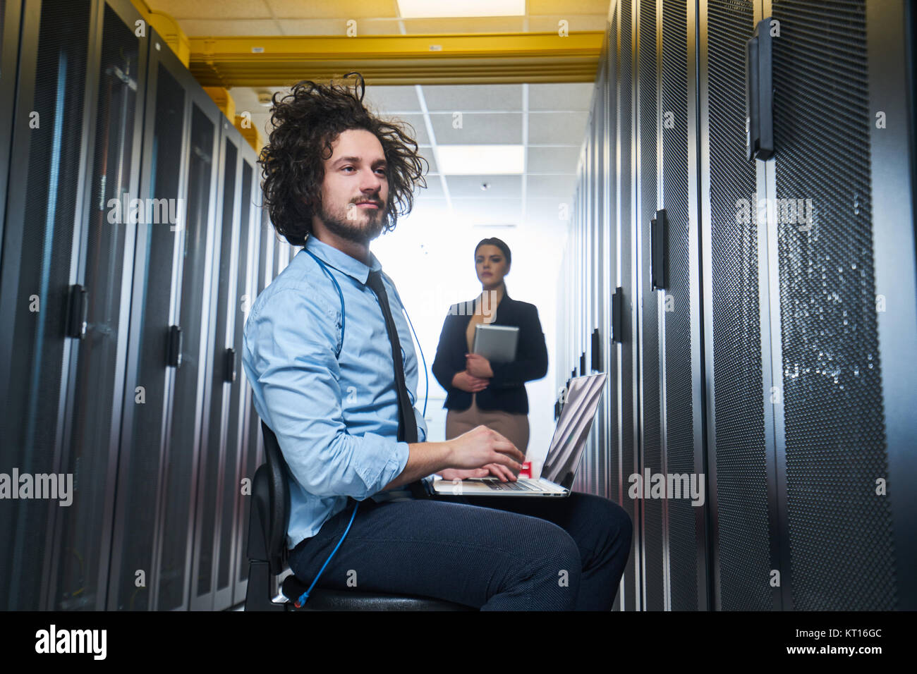 two young technicians working at a data center on server maintenance ...