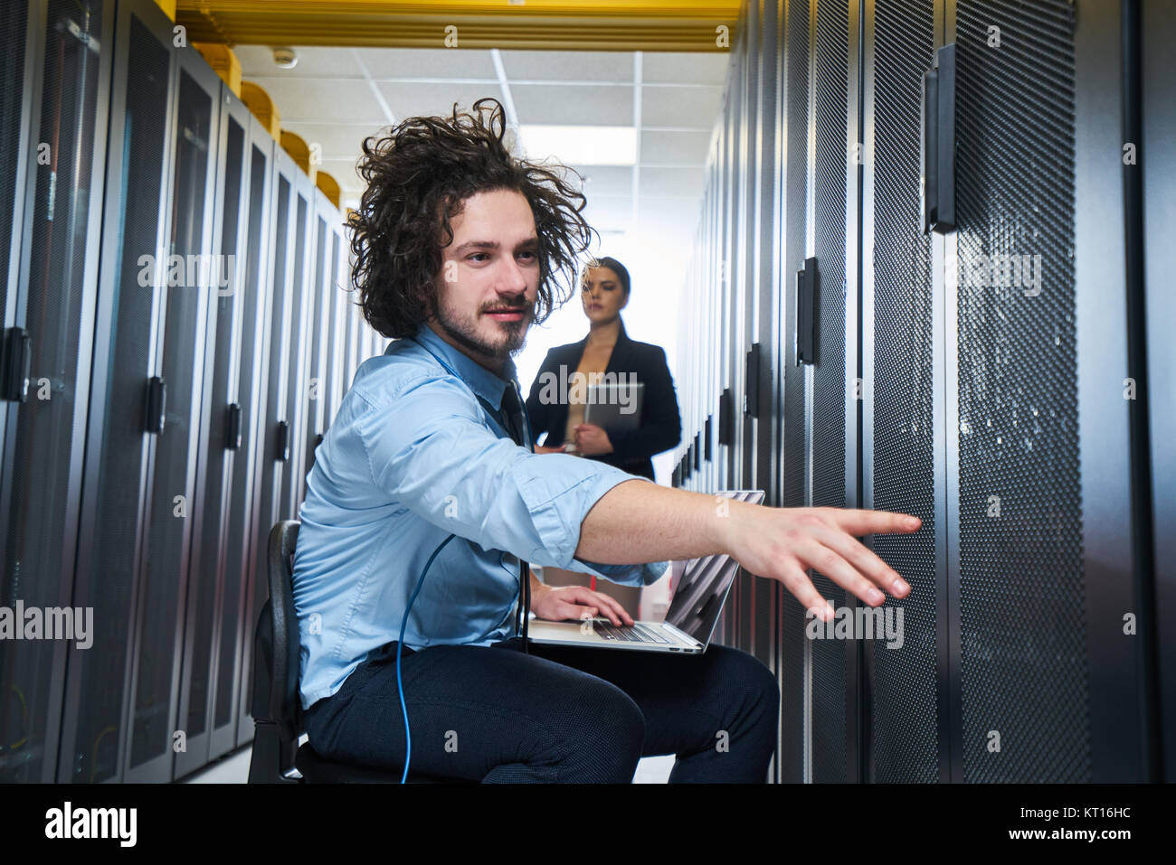 two young technicians working at a data center on server maintenance ...