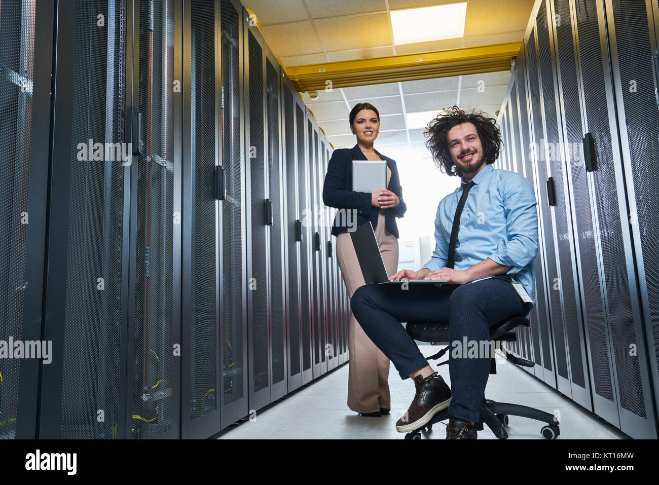 two young technicians working at a data center on server maintenance ...