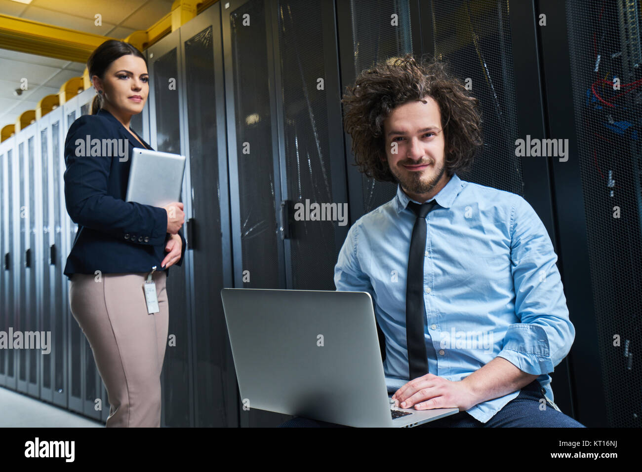 two young technicians working at a data center on server maintenance ...