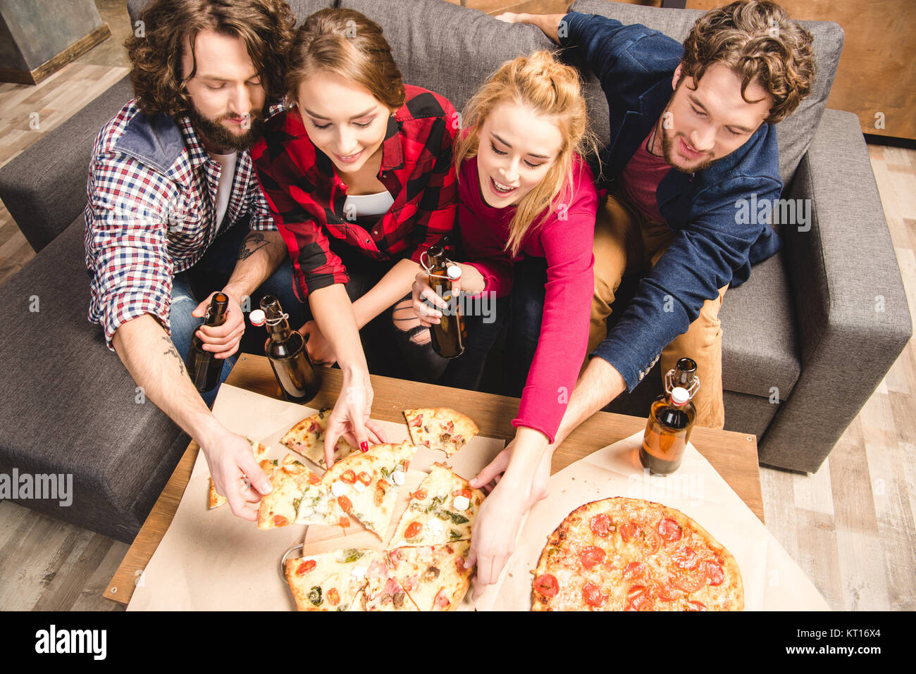 Happy friends enjoying pizza Stock Photo - Alamy
