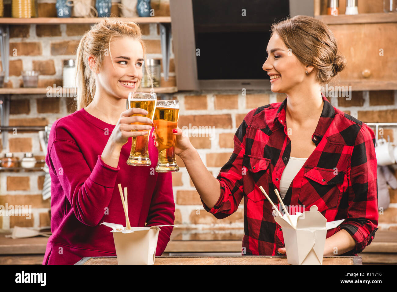 Happy women with noodles and beer Stock Photo - Alamy