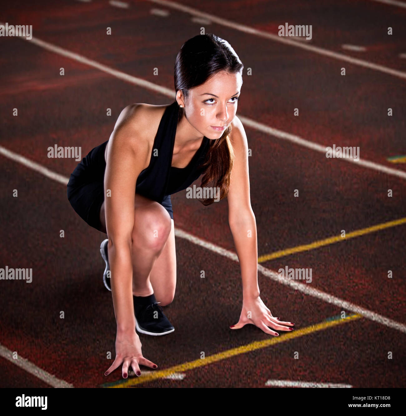 Beautiful female sprinter waiting for the start on a runway Stock Photo ...
