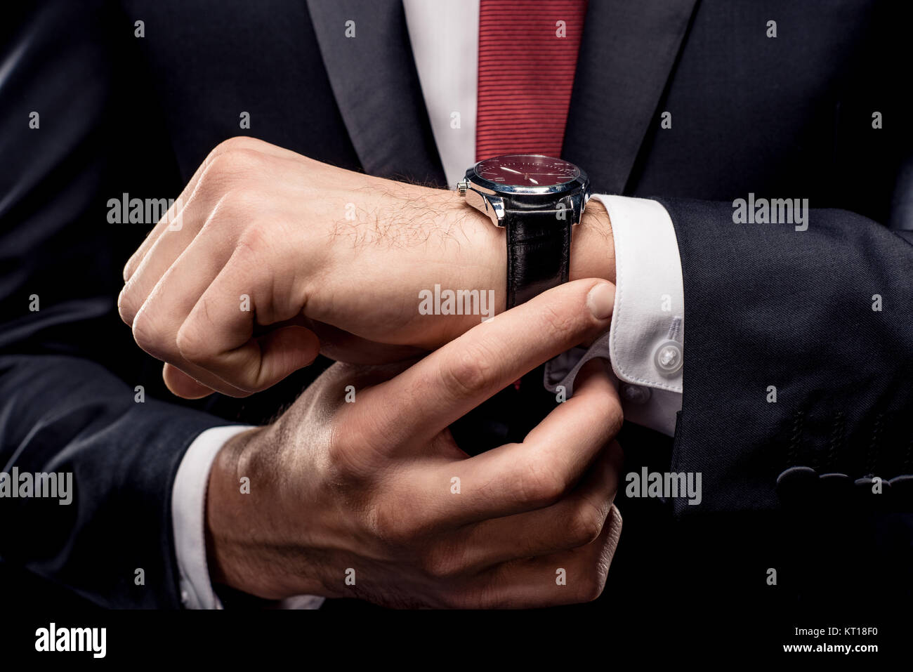 Businessman checking wristwatch Stock Photo - Alamy
