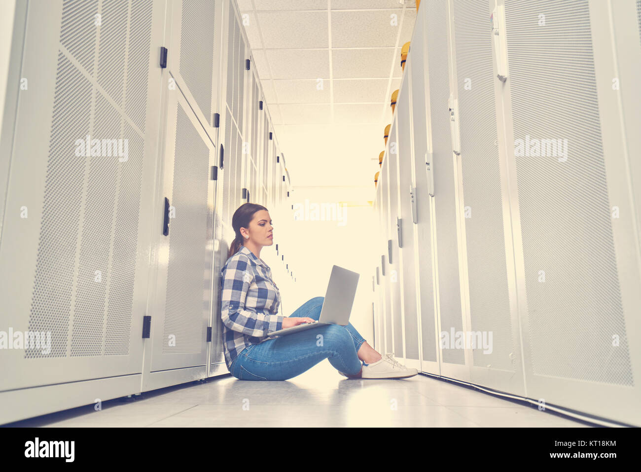 female technician working on server maintenance in white server room ...