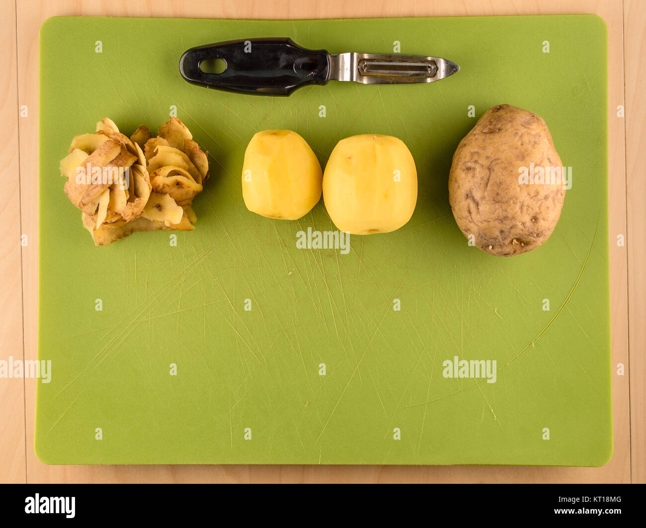 Potatoes, skins and peeler with copyspace Stock Photo - Alamy
