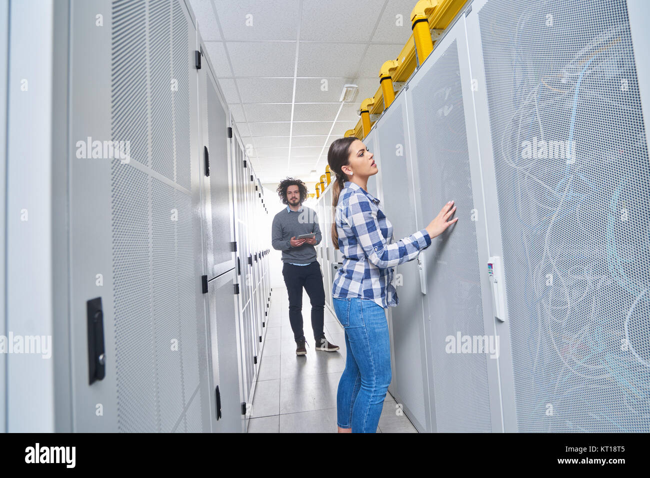 two young technicians working at a data center on server maintenance ...