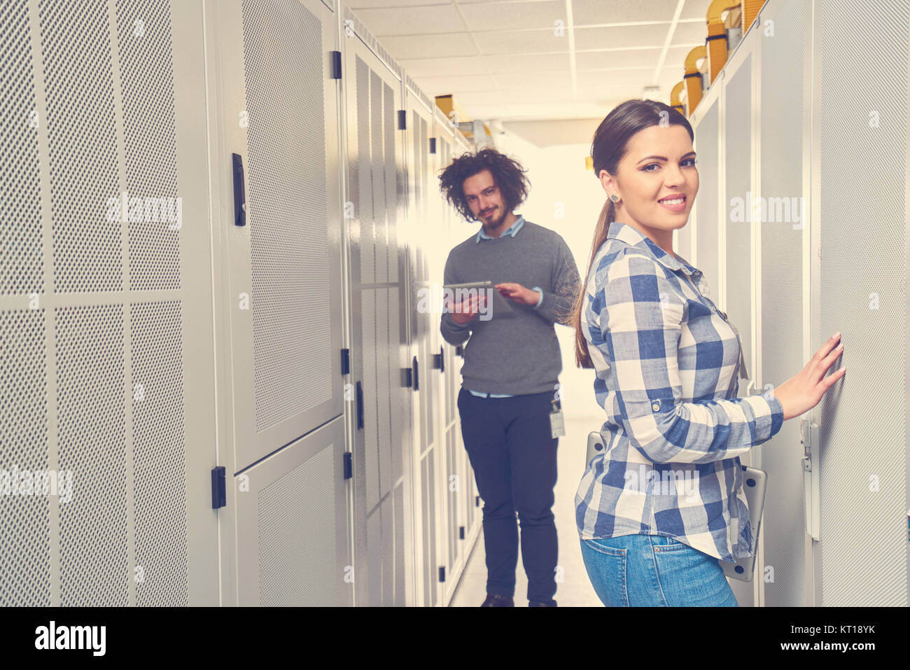 two young technicians working at a data center on server maintenance ...
