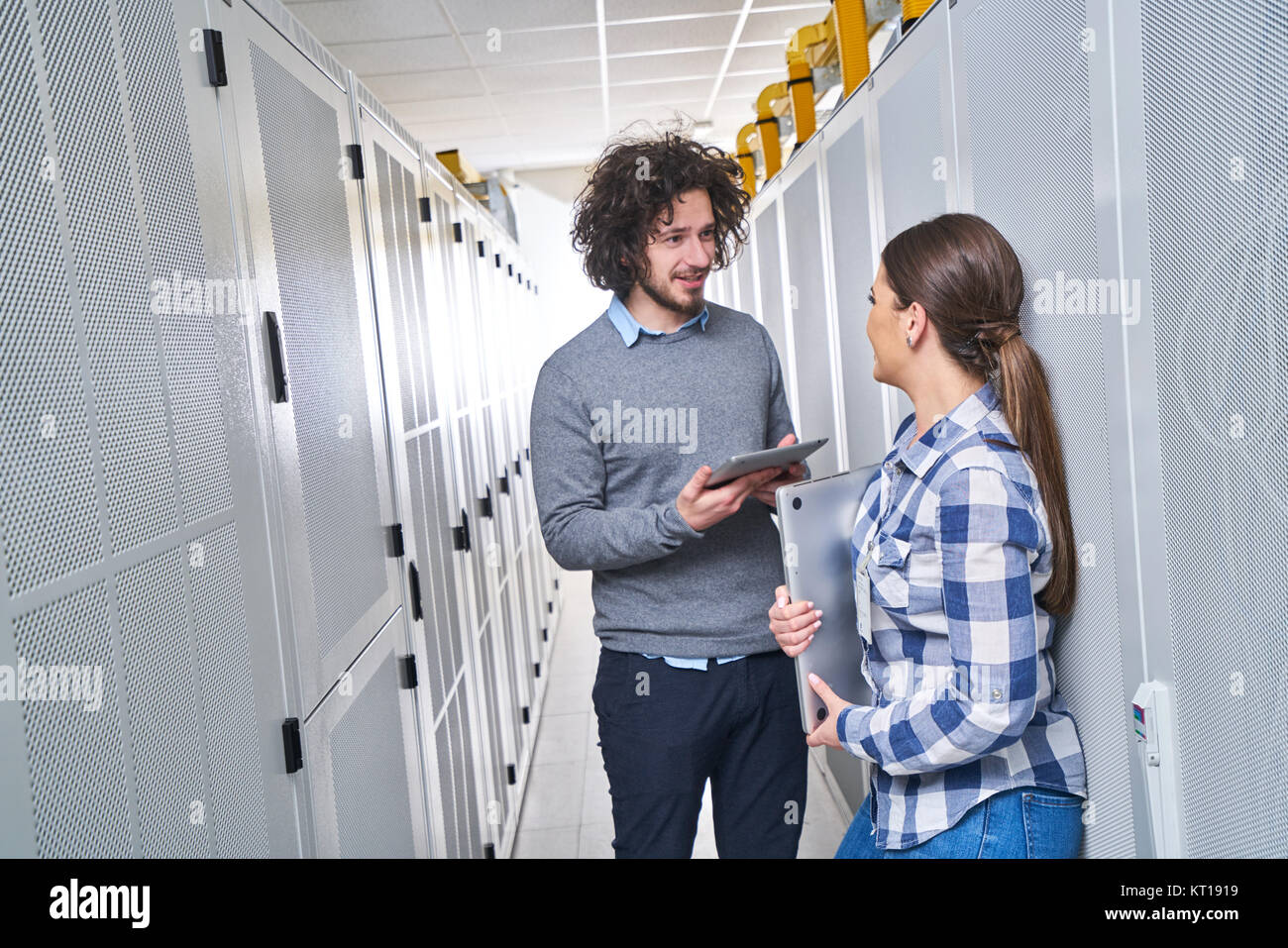 two young technicians working at a data center on server maintenance ...