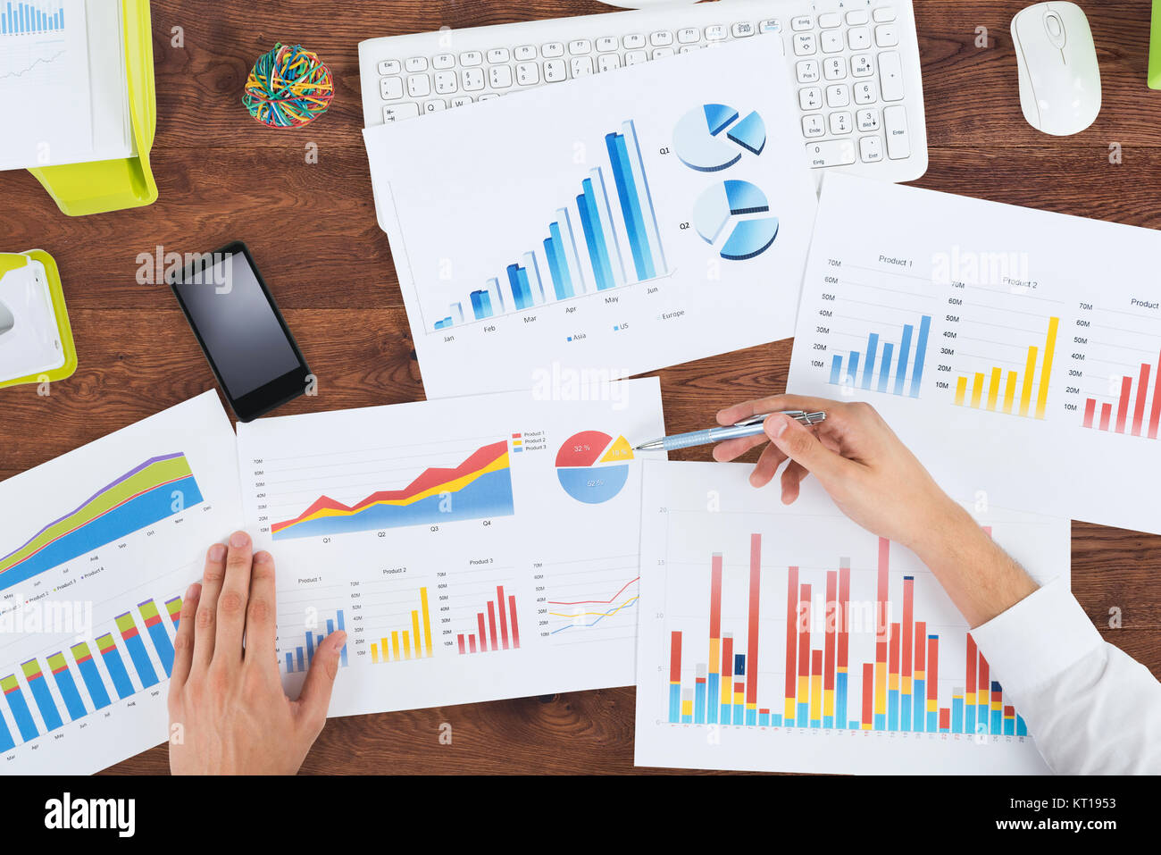 Businessperson Analyzing Graphs At Desk Stock Photo - Alamy
