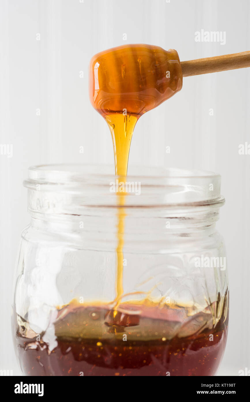 Honey flowing into a jar Stock Photo - Alamy