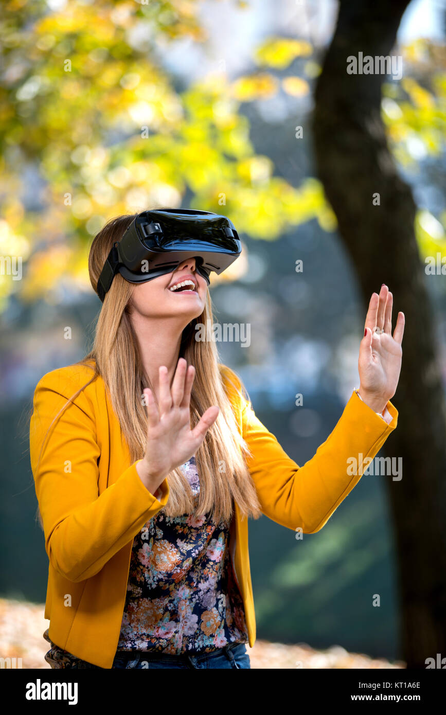 Pretty girl using VR headset outside in the park having fun Stock Photo ...