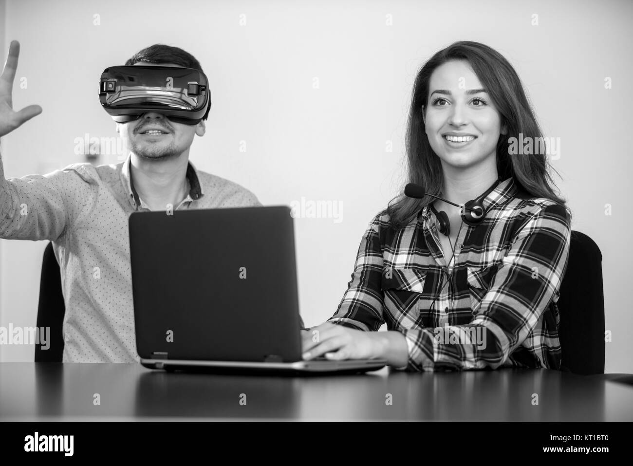 Couple having fun trying VR headset at startup meeting, concept ...