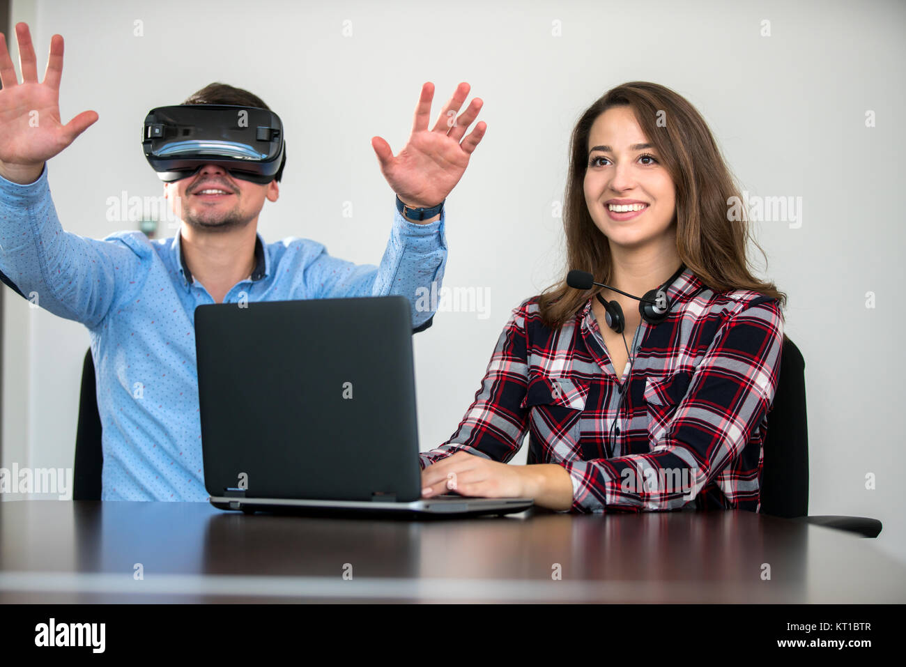 Couple having fun trying VR headset at startup meeting, concept ...