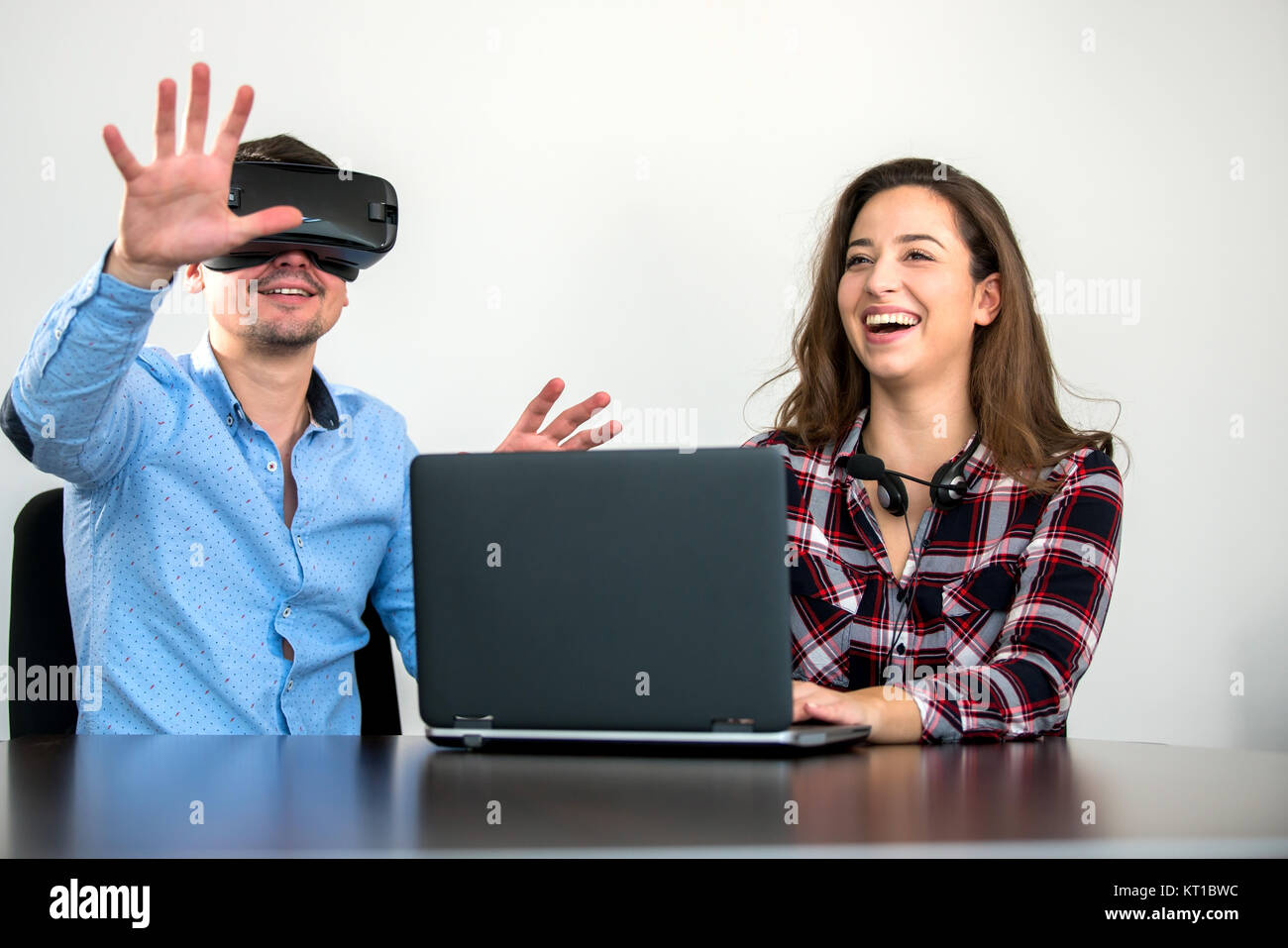 Couple having fun trying VR headset at startup meeting, concept ...