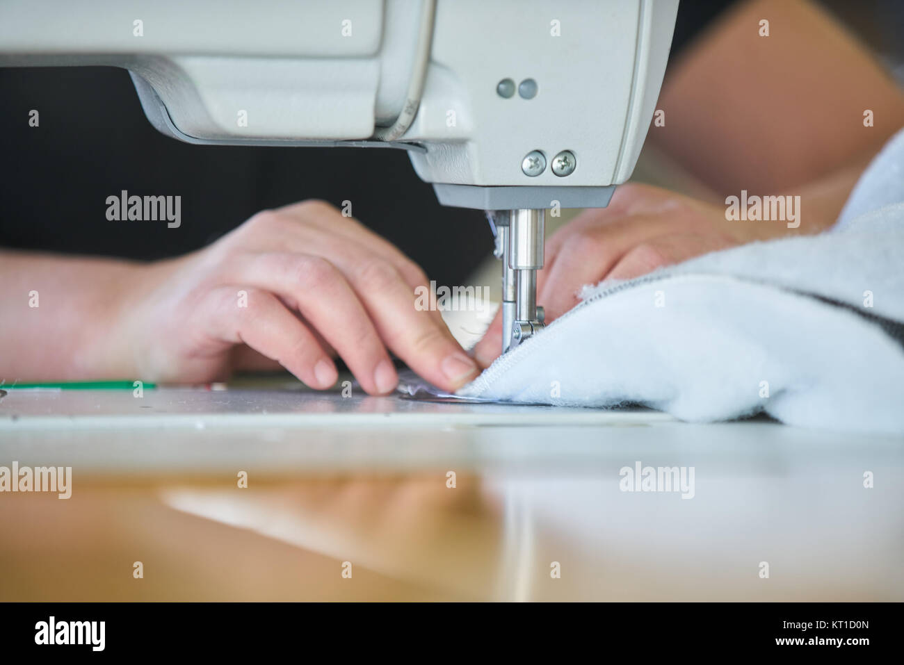 Seamstress or worker in a factory sewing with a industrial sewing ...