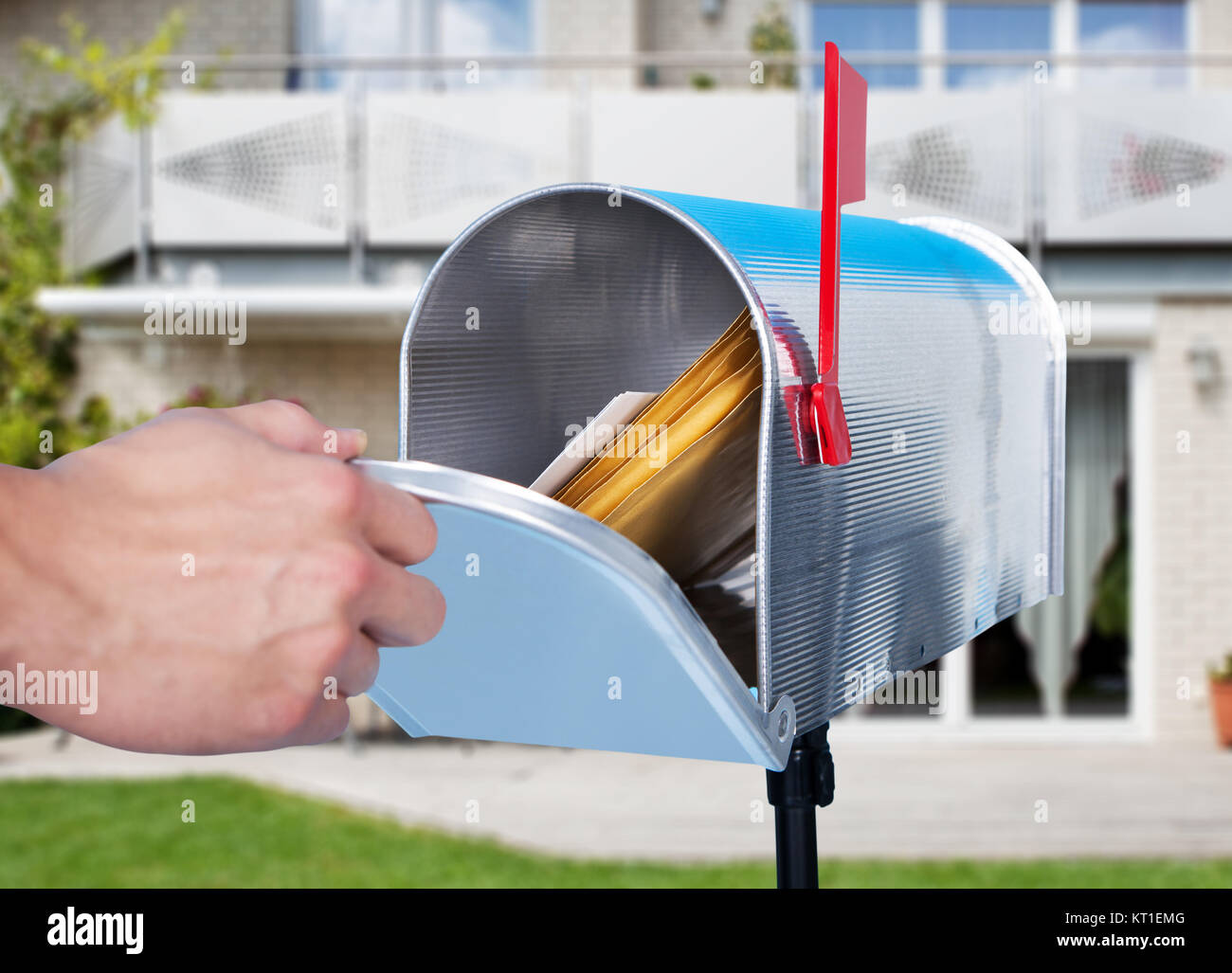 Man opening his mailbox to remove mail Stock Photo - Alamy