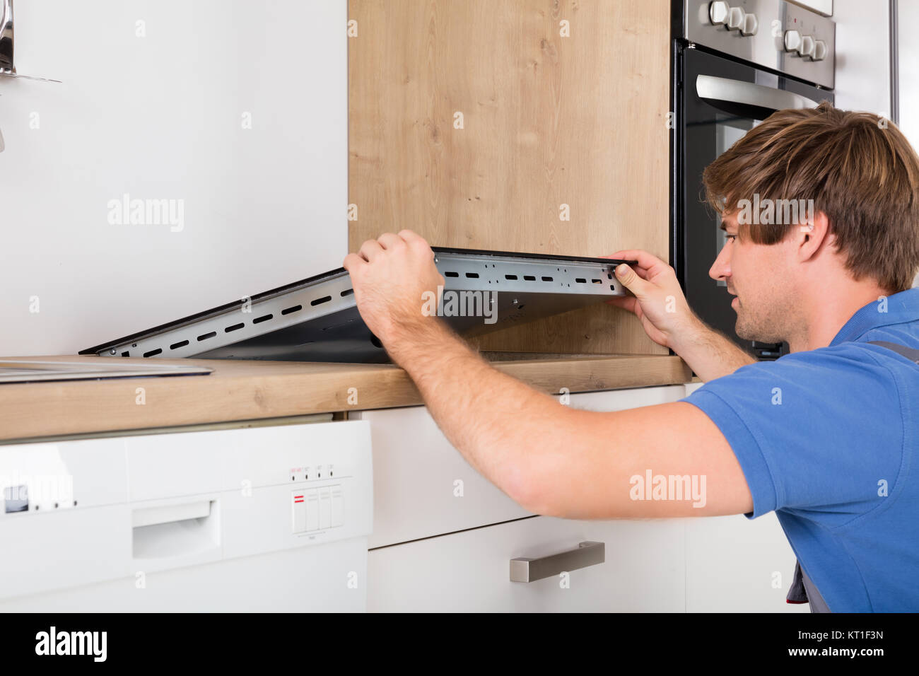 Man In Overall Installing Induction Stove Stock Photo - Alamy