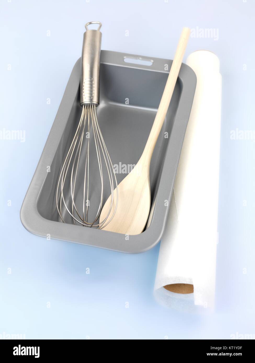 A cake tin and cookng utensils isolated against a blue background Stock ...