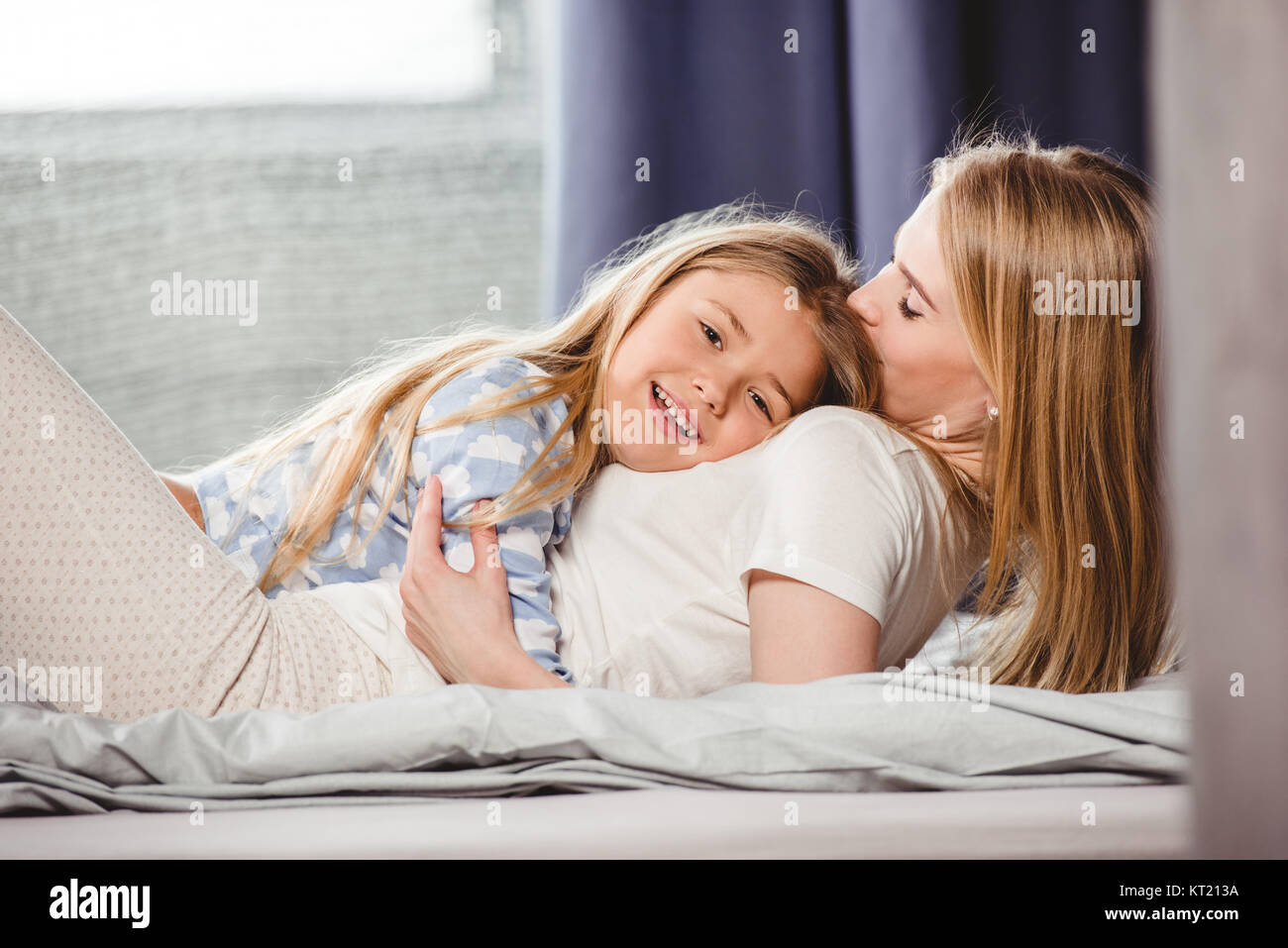 Happy mother and daughter in bed Stock Photo - Alamy