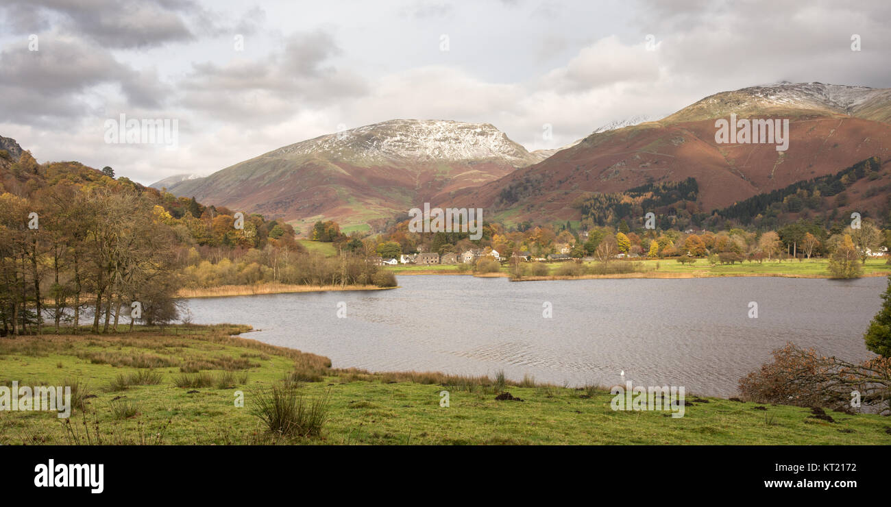 The snow-capped mountain of Seat Sandal rises behind Grasmere lake in ...